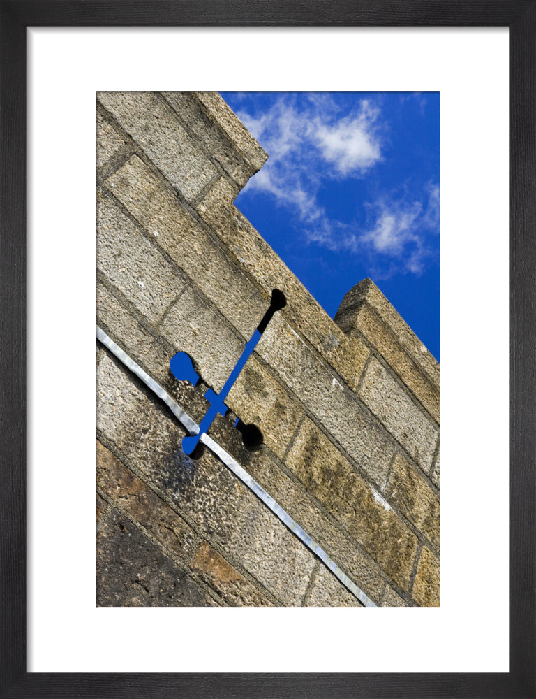 A decorative arrow slit on the battlemented roofline of Castle Drogo ...