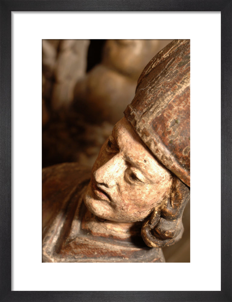 Close view of the head of a carved wooden figure of a bishop, part of ...