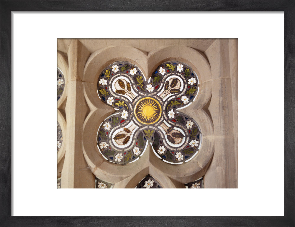 Close view of a quatrefoil stained glass window with sun design in the ...