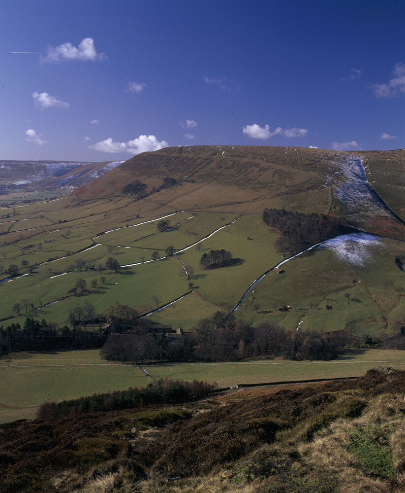 A view of Edale in early spring, snow dusts the side of the hills in s ...